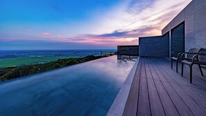 Um terraço moderno ao ar livre com vista para o campo ao pôr do sol.