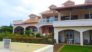 Uma casa com vários andares, piscina, área de estar externa e um jardim.