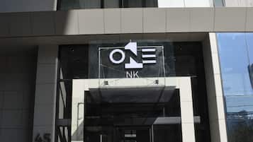 Um edifício moderno com entrada de vidro, uma placa com a inscrição "ONE NK" e o número "45" na lateral.