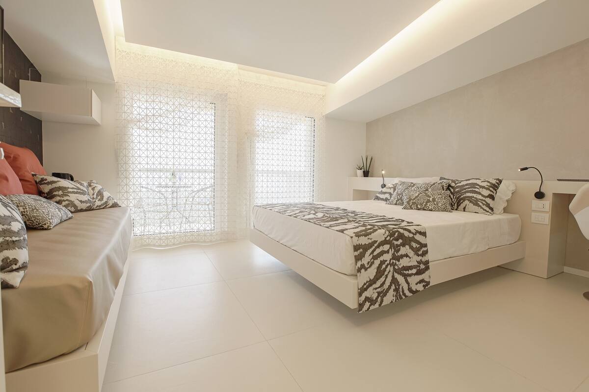 Quarto moderno com uma cama grande, um sofá e uma escrivaninha.
