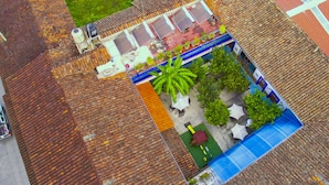 Vista aérea de um terraço com piscina, áreas de estar e um reservatório de água.
