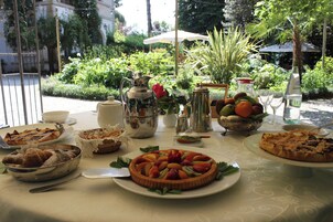 Mesa posta com diversos pratos e vista para um jardim.