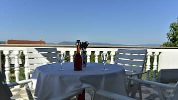 Mesa posta para dois, com garrafa e copos, com vista panorâmica.