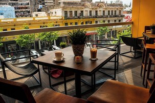 Uma varanda com uma mesa, cadeiras e um vaso de planta.