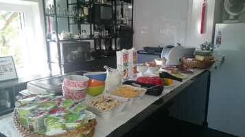 Disposição de buffet com diversos alimentos e bebidas.