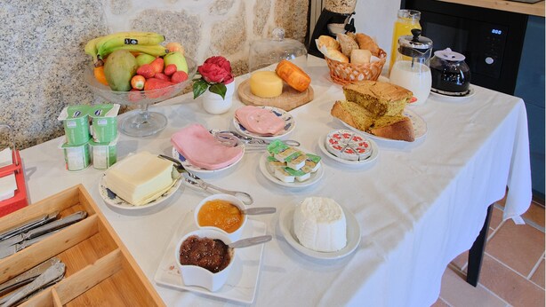 Um buffet de café da manhã com diversos alimentos e utensílios.