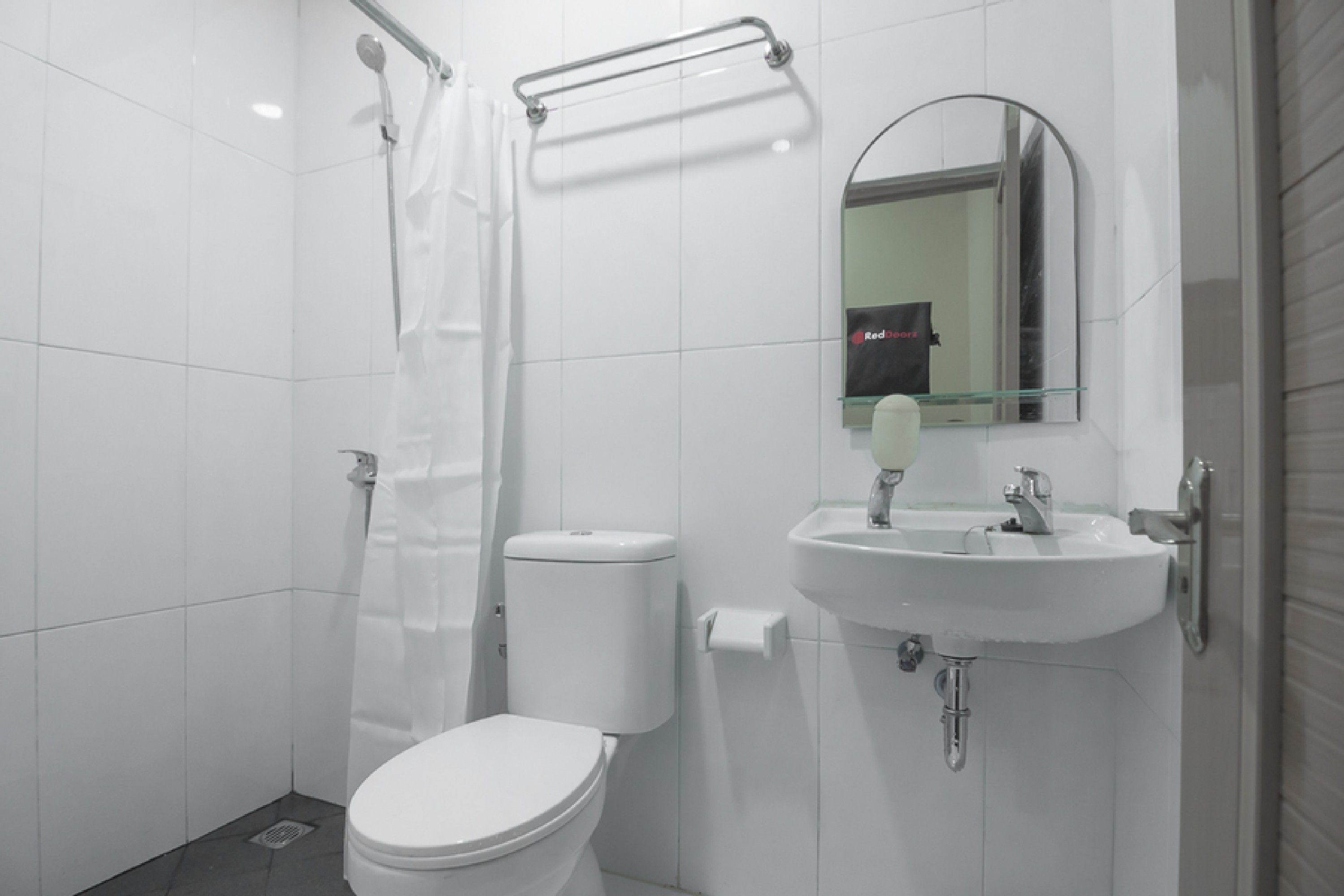Uma casa de banho moderna com sanita, chuveiro e lavatório.