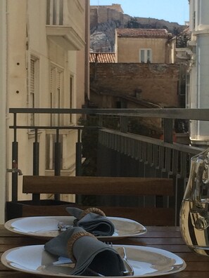 Uma varanda com vista para a paisagem urbana, mostrando edifícios com arquitetura tradicional e um céu claro.