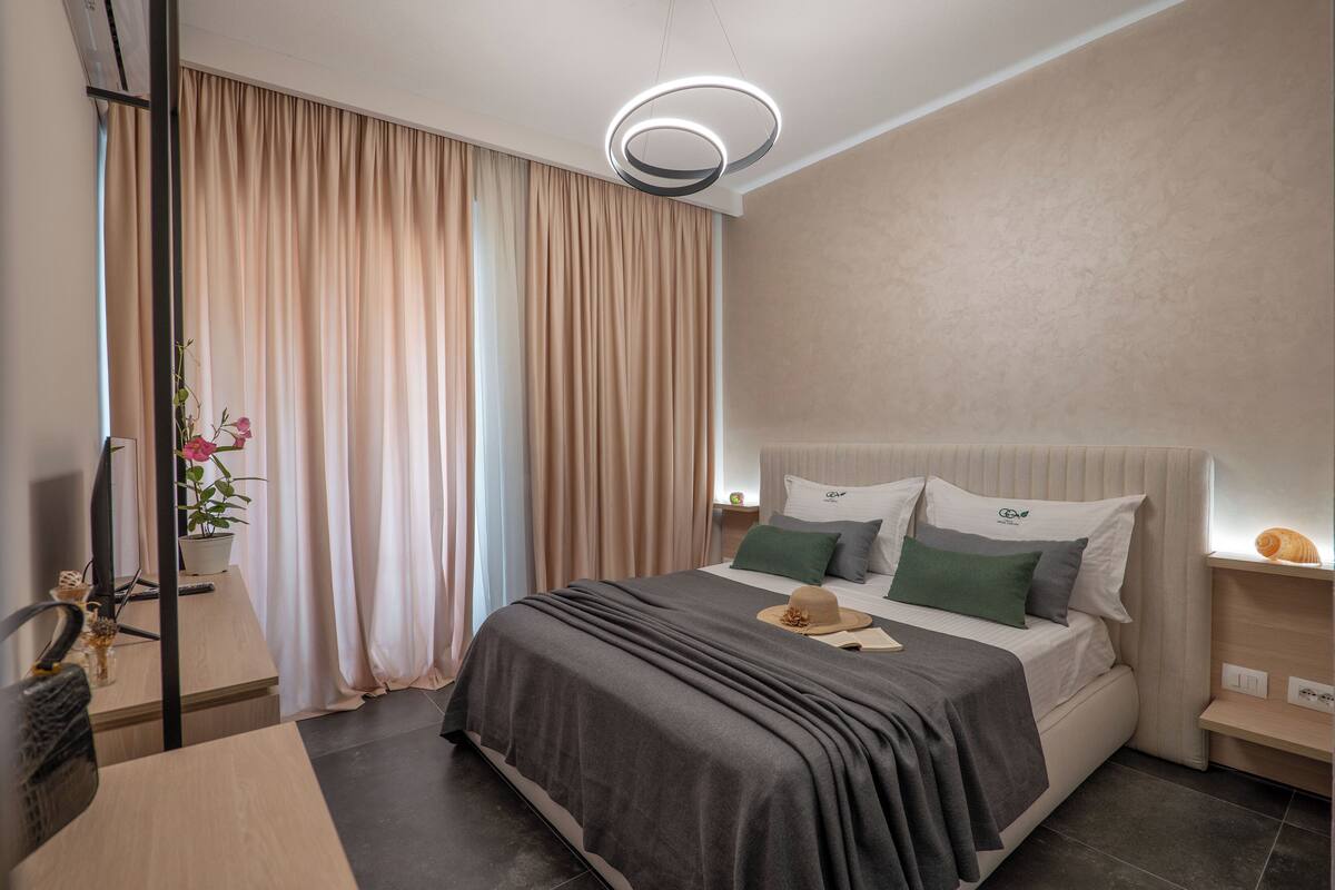 Quarto de hotel moderno com uma cama grande, uma escrivaninha e uma cadeira.