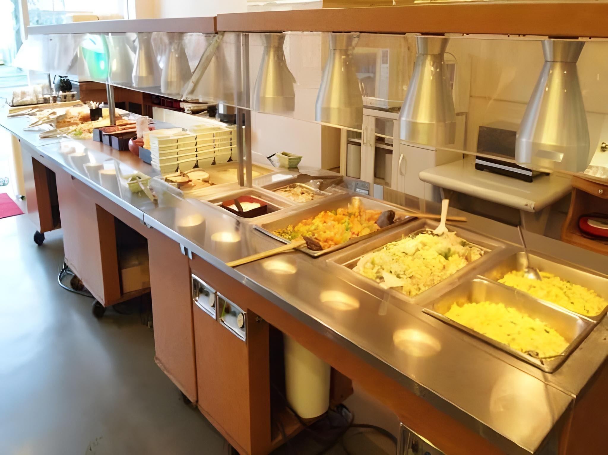 Disposição de buffet com várias estações de comida e utensílios.