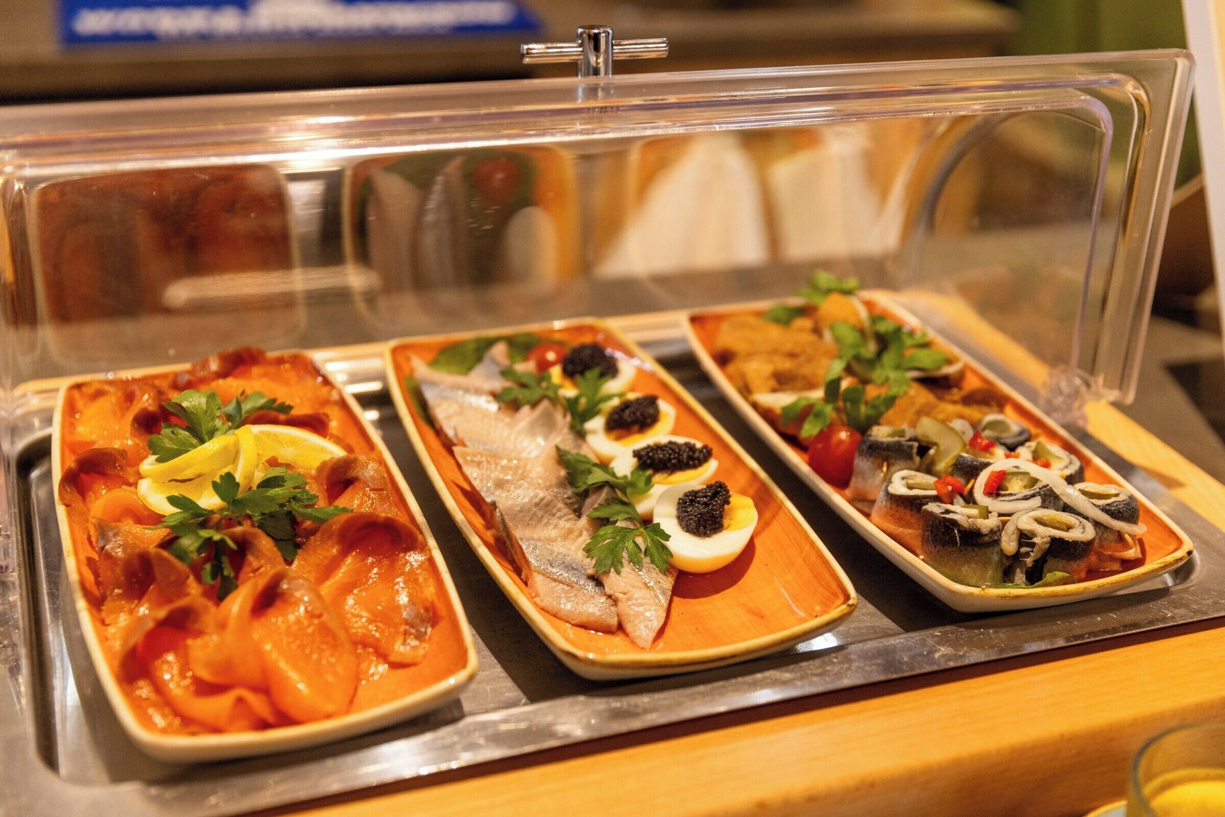 Buffet com diversos pratos, incluindo peixe, legumes e acompanhamentos.