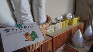 Quarto com almofadas, cestos e uma placa com personagem de desenho animado.