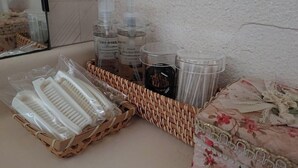 Um banheiro com espelho, amenities e uma cesta de vime.