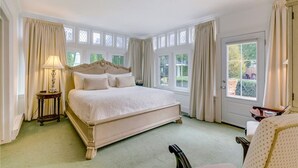 Quarto espaçoso com uma cama grande, várias janelas e vista para o exterior.