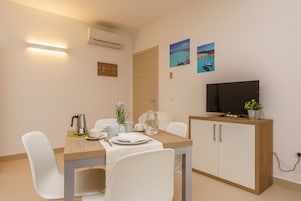 Apartamento Deluxe, kitchenette, vista para a piscina | Sala de estar | Televisor de ecrã plano de 40 polegadas com canais digitais, televisor 