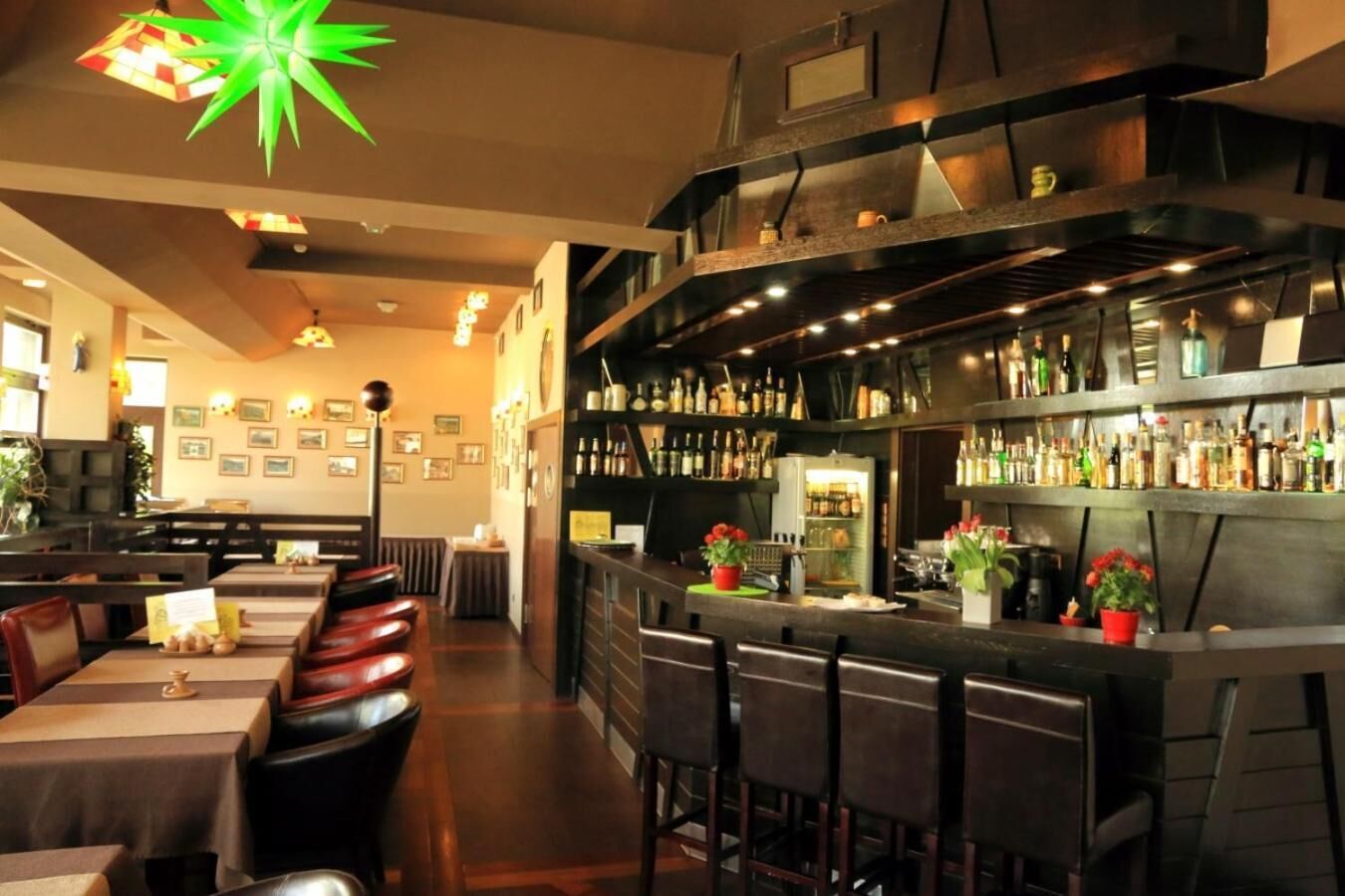 Restaurante com área de bar, mesas e cadeiras de madeira.