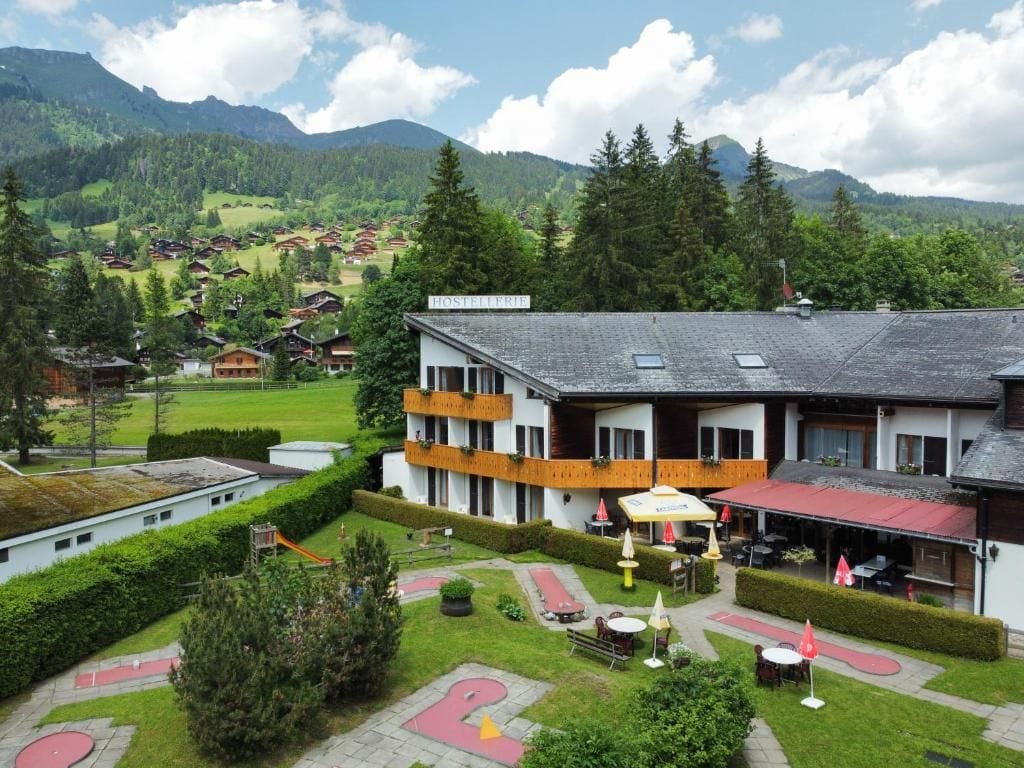 Hotel com um pátio, área de estar ao ar livre e montanhas ao fundo.