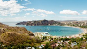 Uma vila costeira com uma praia, barcos e casas.