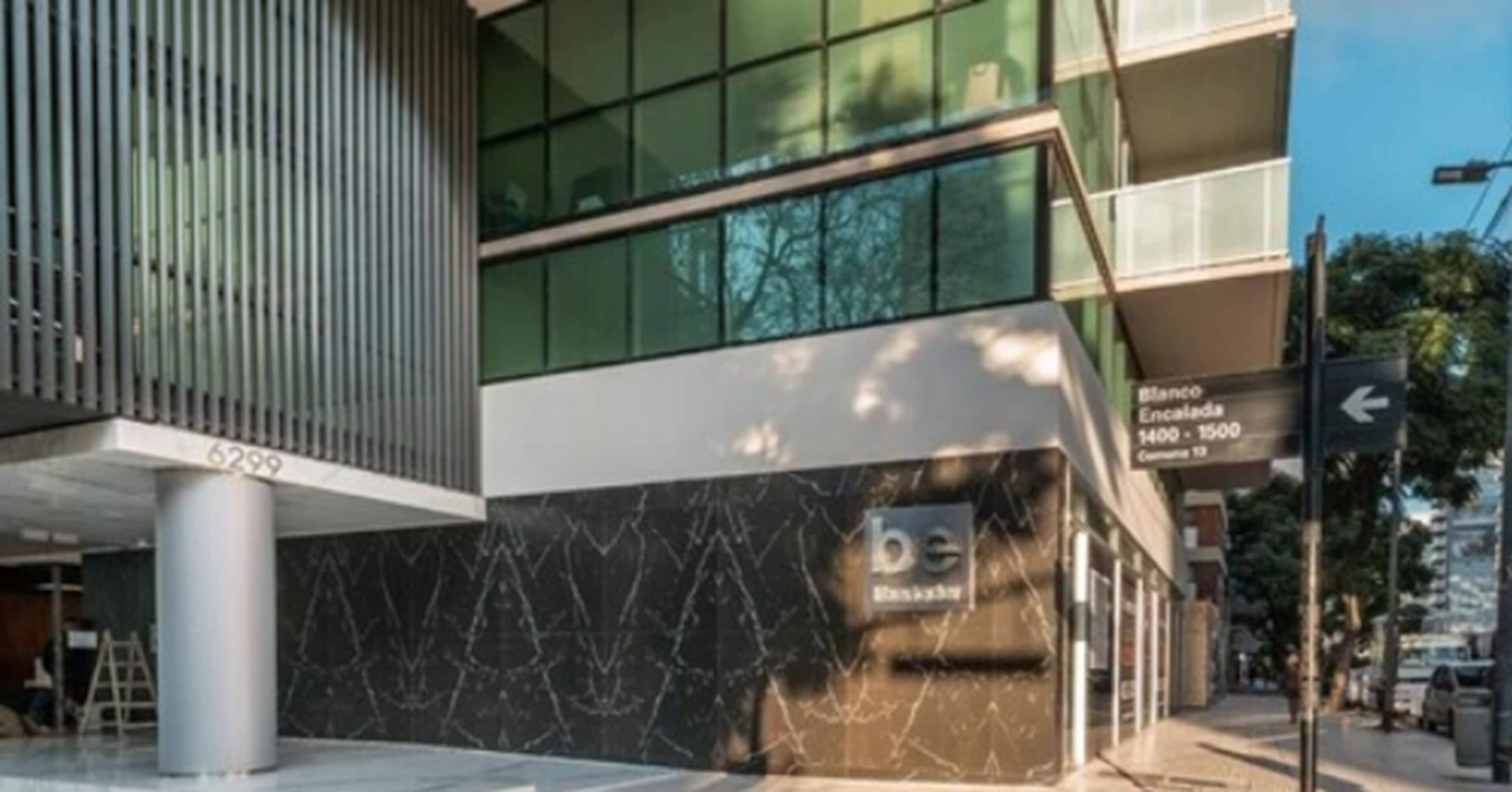 Um edifício moderno com amplas janelas e fachada de mármore preto.