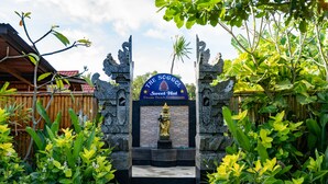 Placa para 'The Soggol Sweet Hut' com uma estátua na frente.