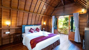 Quarto de cabana de madeira com uma cama grande, paredes de madeira e varanda com cortinas.