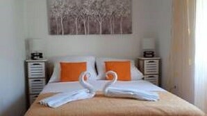 Quarto com cama, duas mesas de cabeceira, um quadro e uma janela.
