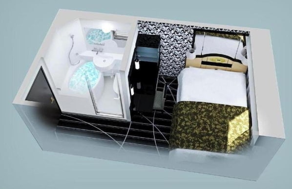 Quarto de hotel compacto com cama, banheiro pequeno e um espaço de estar.