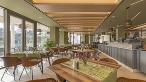 Um restaurante espaçoso com pé-direito alto, amplas janelas e decoração de interiores moderna.