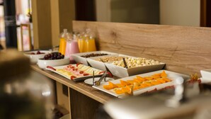 Buffet com diversas opções de alimentos, incluindo frutas, cereais e bebidas.