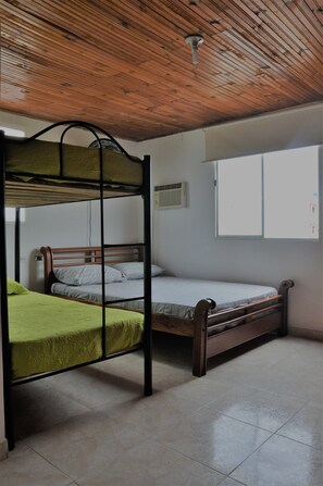 Um quarto com uma cama de solteiro, uma cama individual, uma janela e um armário.