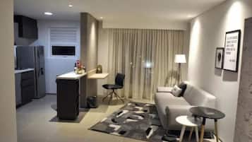 Suite Deluxe, várias camas | Sala de estar | TV de ecrã plano