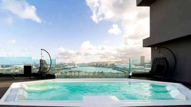 Piscina no terraço com vista para a cidade, incluindo um porto e edifícios.