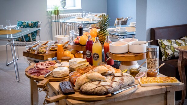 Um buffet de café da manhã com diversos alimentos e bebidas.