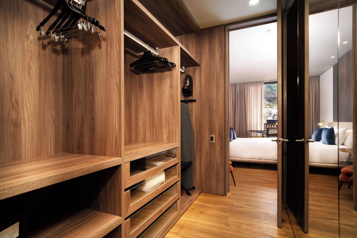 Quarto moderno com estantes de madeira, uma cama e vista para o exterior.