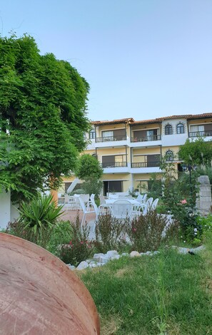 Um edifício com vários andares, varandas, área de estar ao ar livre e um jardim.
