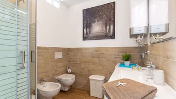Apartamento, 2 quartos | Banheiro | Chuveiro, secador de cabelo, roupões de banho, bidê