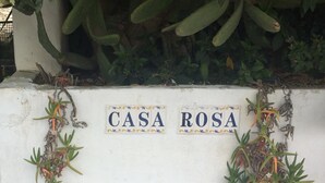 Paredes brancas com duas placas que dizem 'CASA ROSA'.