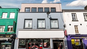 Um edifício com vários andares, com uma loja no térreo e um restaurante no segundo andar.