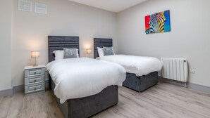 Quarto moderno com duas camas, um radiador e um claraboia.