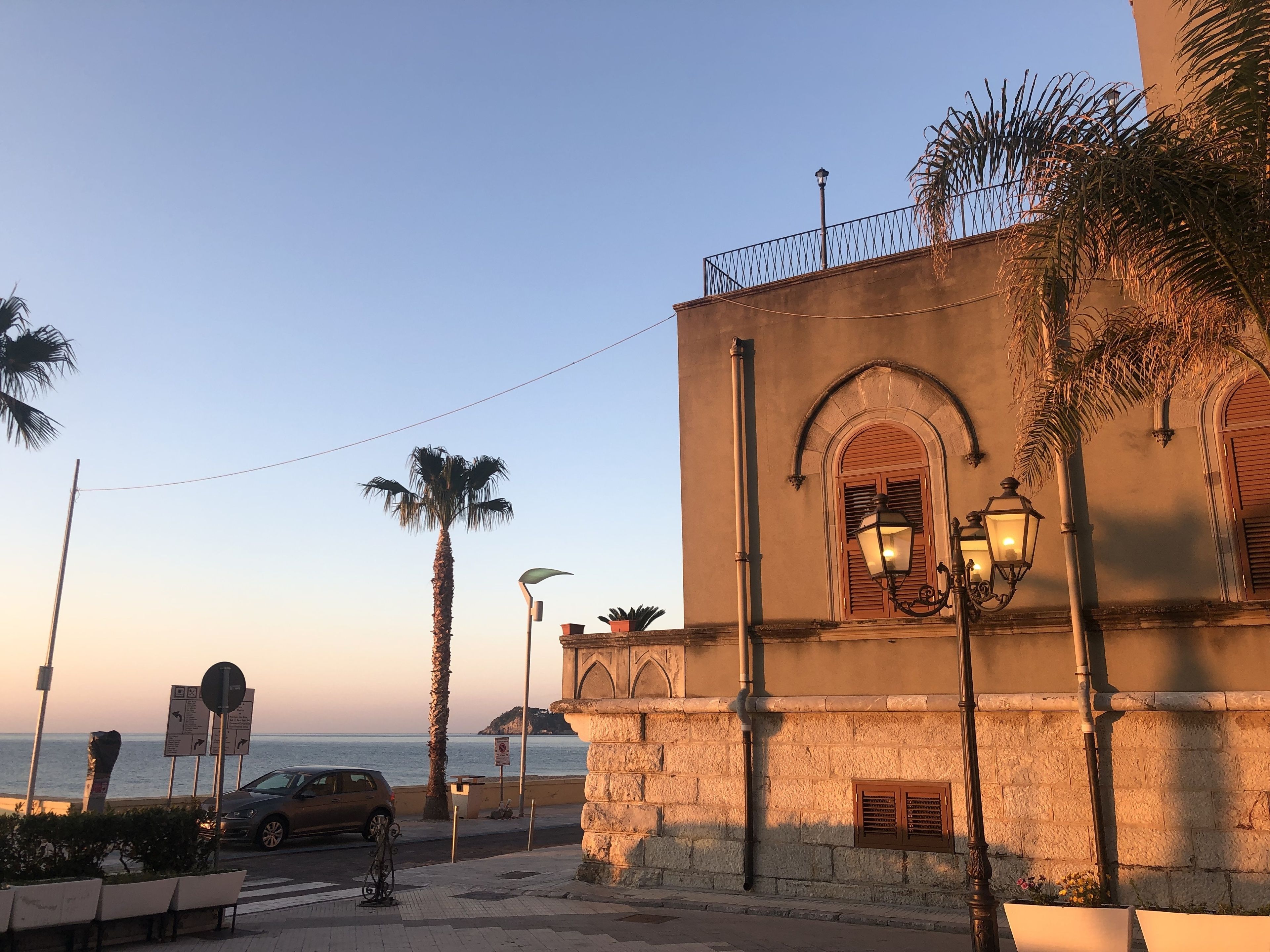 Um edifício à beira-mar com janelas em arco e uma varanda, com vista para o oceano.