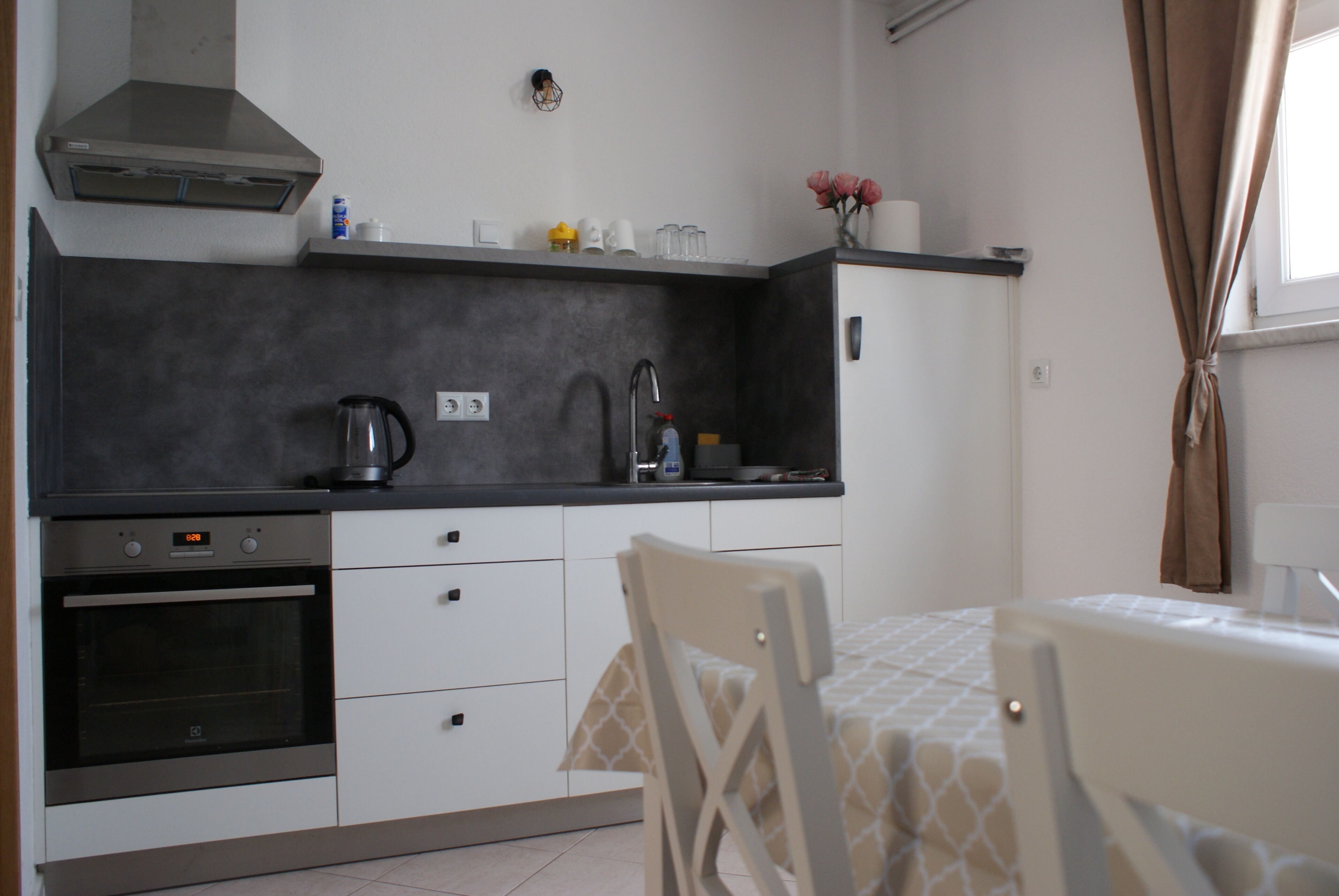 Uma cozinha moderna com forno embutido, cafeteira e pia.