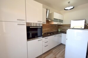 Apartamento, 2 quartos (on the first floor (bijeli)) | Cozinha privada | Geladeira grande, micro-ondas, fogão, cooktop