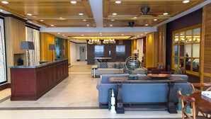 Um hall amplo com balcão de recepção, área de estar e uma grande mesa de jantar.