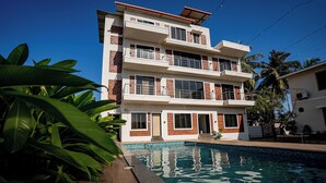 Um edifício de vários andares com uma piscina em primeiro plano.
