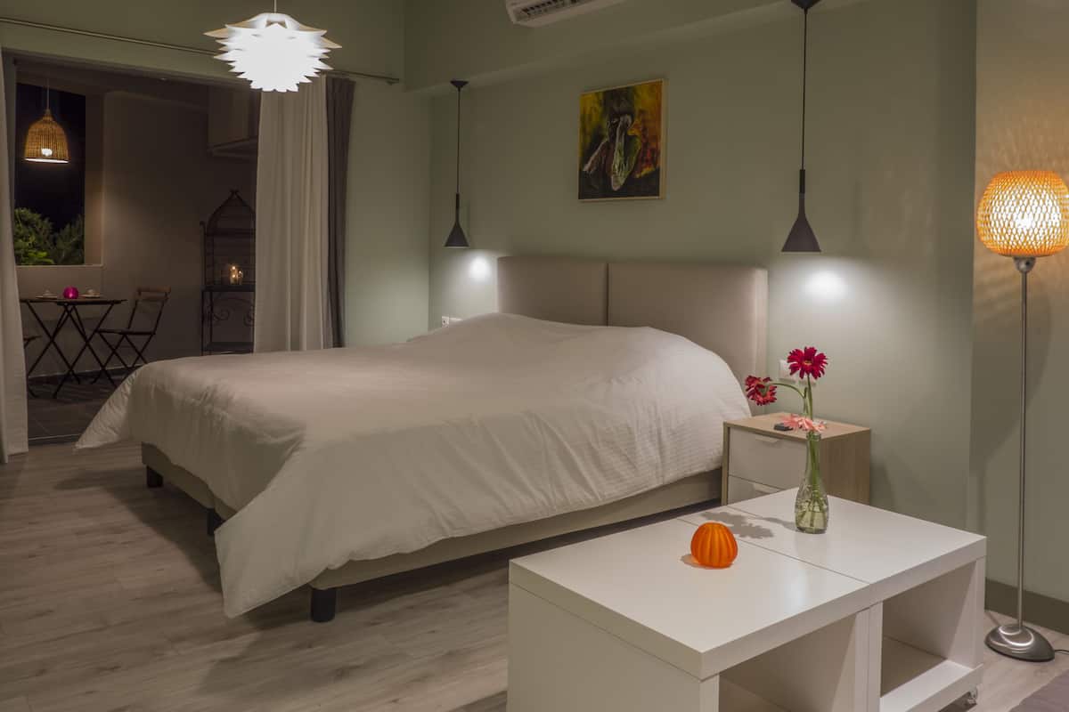 Quarto moderno com cama grande, mesas de cabeceira e abajur.