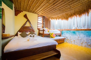 Quarto com cama, cabeceira de madeira, janela com cortinas e vista para uma piscina.