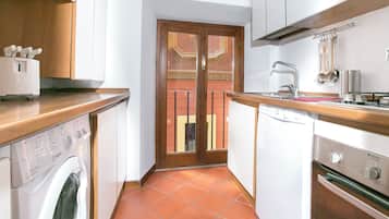 Apartamento, 2 quartos | Cozinha privada | Geladeira grande, micro-ondas, fogão, cooktop
