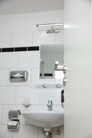 Chuveiro, toalhas de banho, sabonete, shampoo