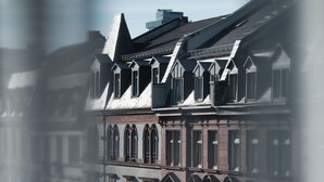 Um edifício de vários andares com estilo arquitetônico clássico, com janelas em arco e fachada simétrica.