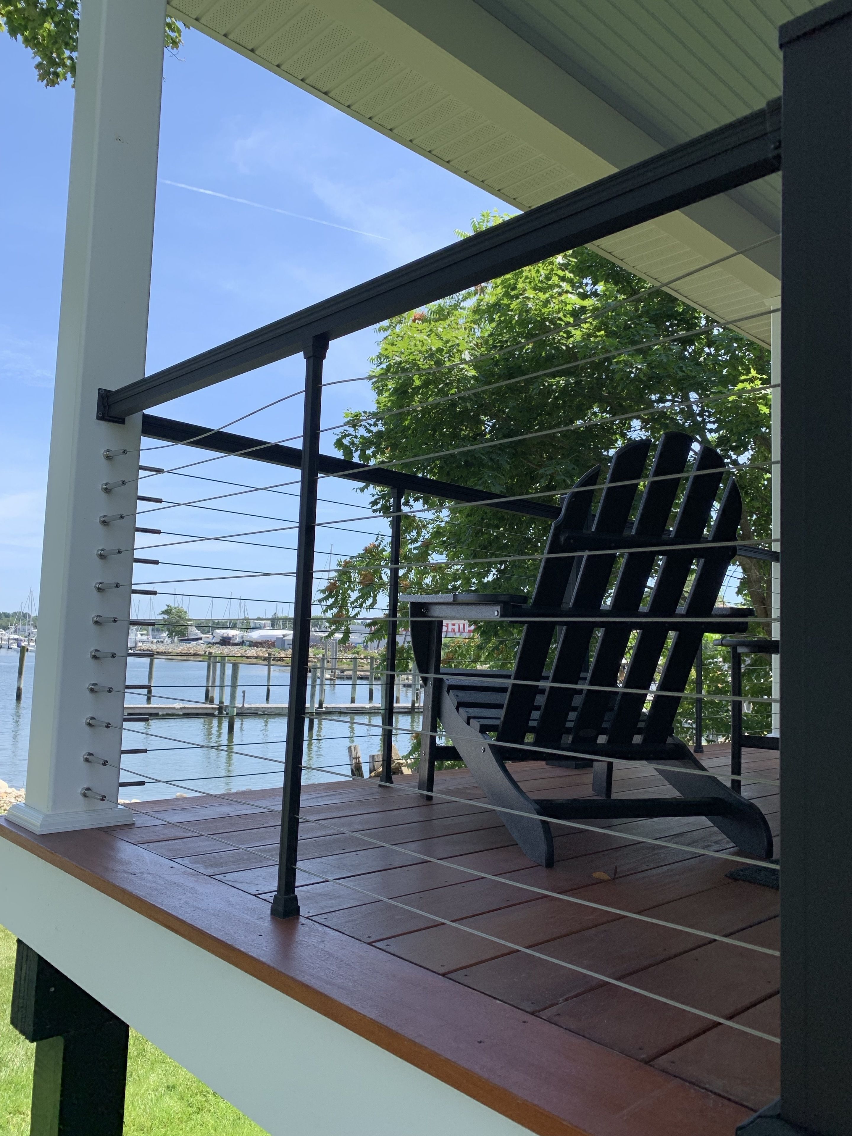 Uma área de estar coberta ao ar livre com vista para um porto e barcos atracados.